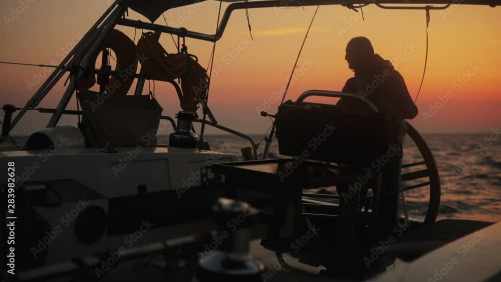 Sailor using wheel to steer rudder on a sailing boat. Stock ビデオ | Adobe ...