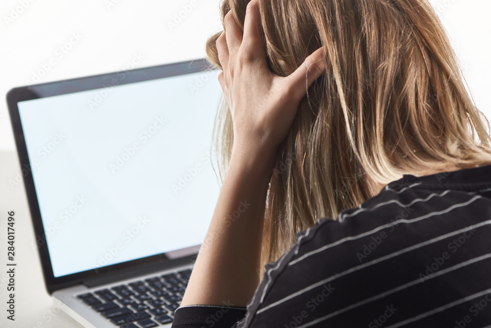 offended blonde girl as victim of cyberbullying sitting near laptop ...