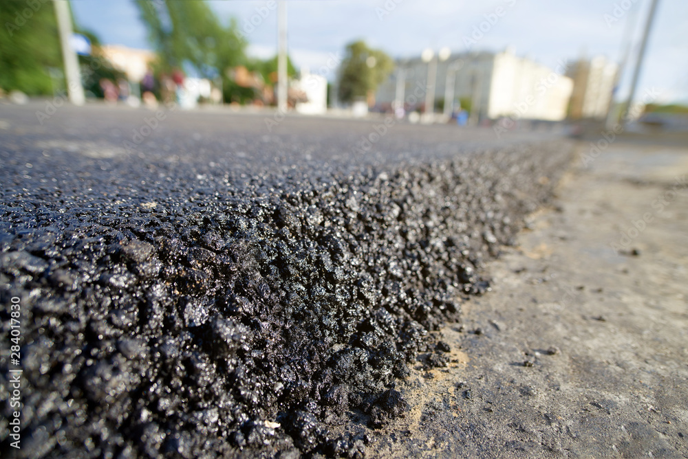 Road construction and repairing works. Layer of new asphalt surface ...