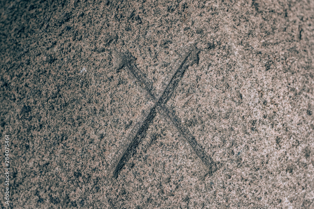 Sign X carved on the stone. Letter of the alphabet on granite. Stone ...