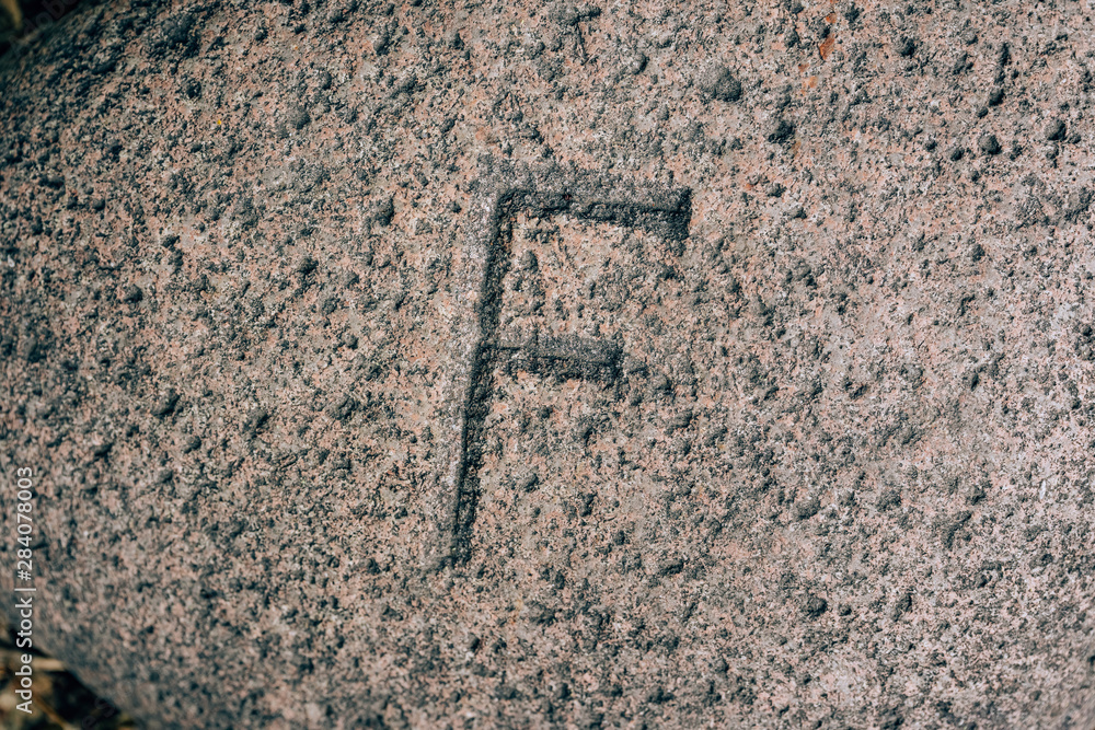 Letter F carved on the stone. Letter from the alphabet on granite ...