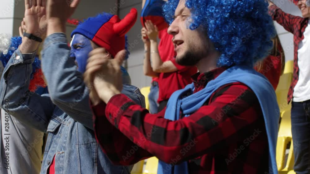 Vidéo Stock Medium shot of devoted young sports fans in brightly ...