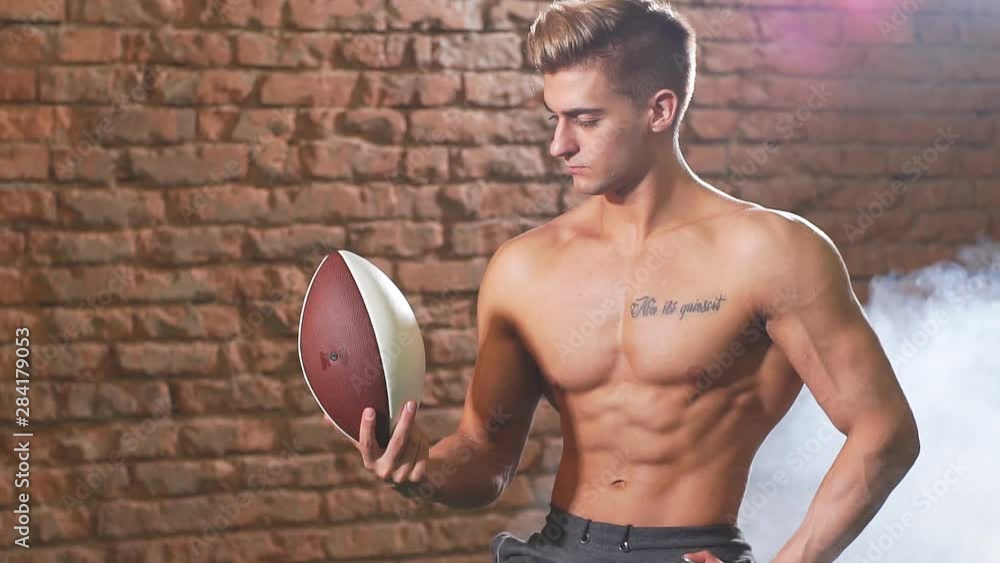 Handsome American football player model with muscular torso, poses with ...