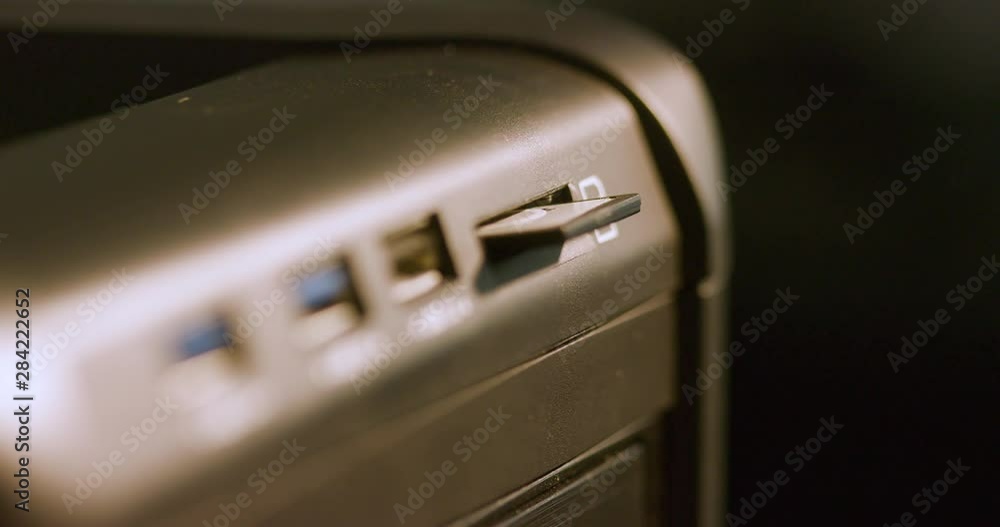 The hand of a Caucasian male inserting a memory card into the ...