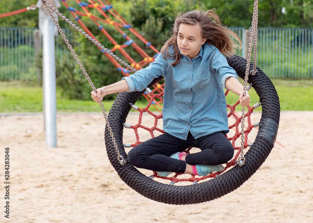 Happy teen girl on swing in playground outdoors. Beautiful student ...