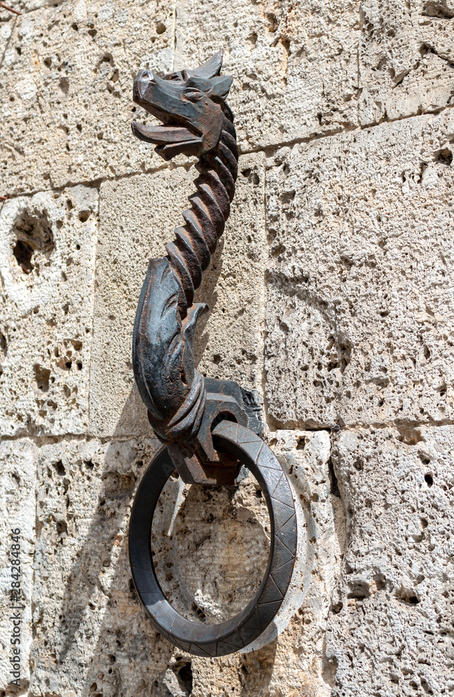 Old metal horse hitching ring on a wall in Siena. The city is famous ...