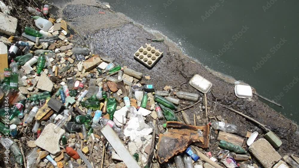 Plastic bags, bottles, garbage and trash dumped in river in nature ...