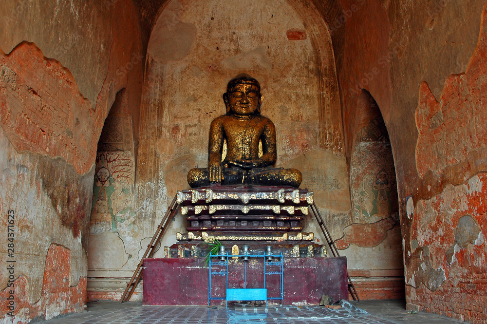 Myanmar, Bagan, Statue of a sitting golden Bhudda on his worship altar ...