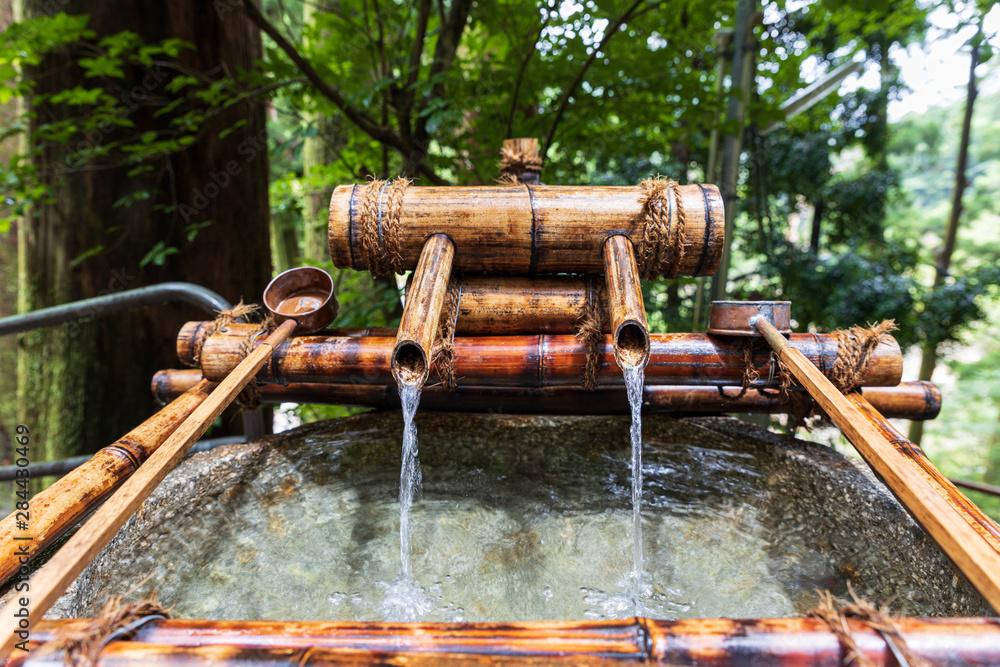 Water flows through bamboo into traditional wash basin at Japanse ...