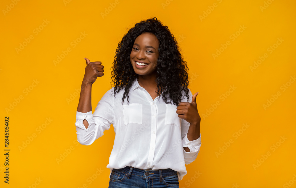 Happy black woman showing thumbs up at studio Stock Photo | Adobe Stock Happy black woman showing thumbs up at studio Stock Photo | Adobe Stock
