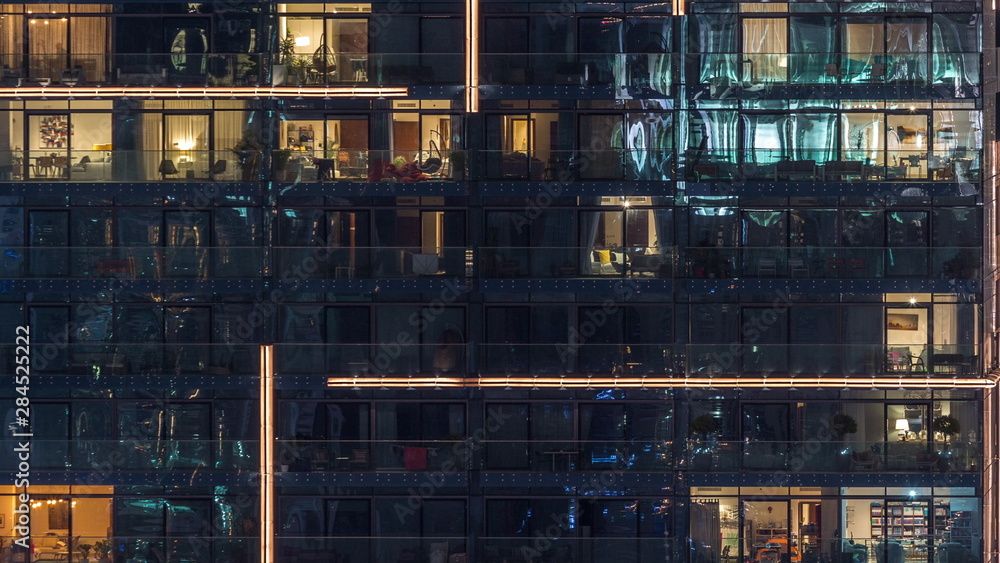 Lights in windows of modern multiple story building in urban setting at ...