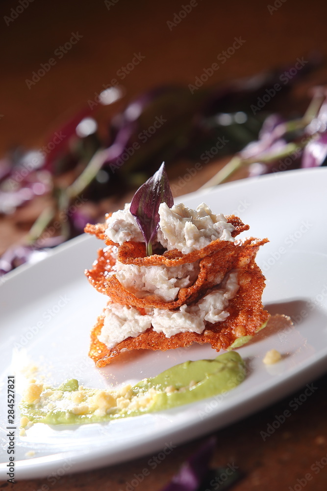 Chicharrón enchilado with goat cheese and avocado sauce. Stock Photo ...
