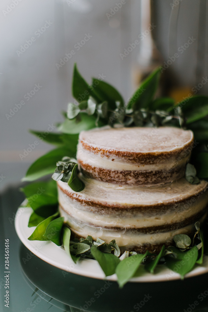 simple two tier naked wedding cake with greenery Stock Photo | Adobe Stock