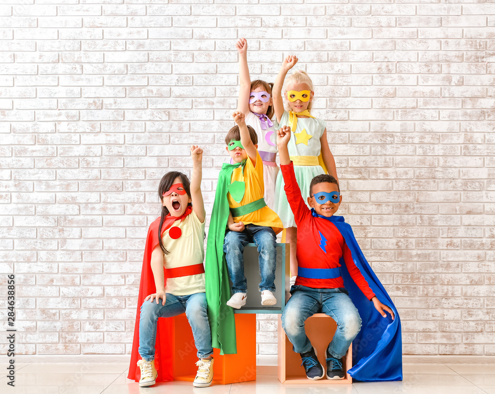 Cute little children dressed as superheroes near brick wall Stock Photo ...