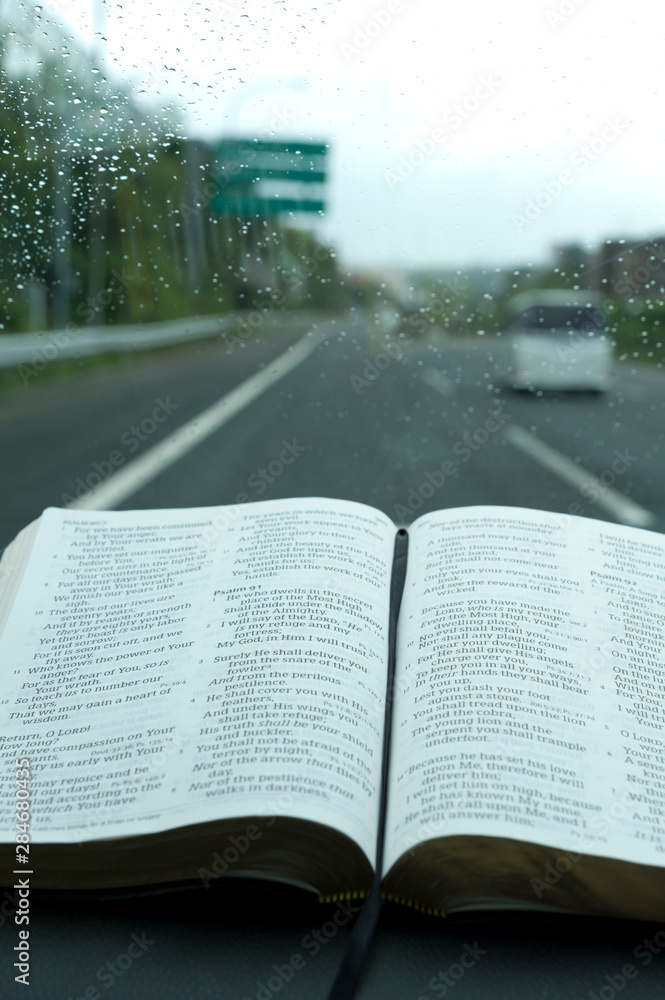 Beautiful view of open Holy Bible in Psalm 91 in rainy day. Blurred ...