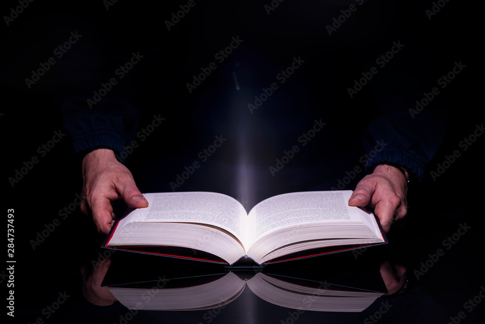 Person reading book with glowing light coming from inside of it. High ...