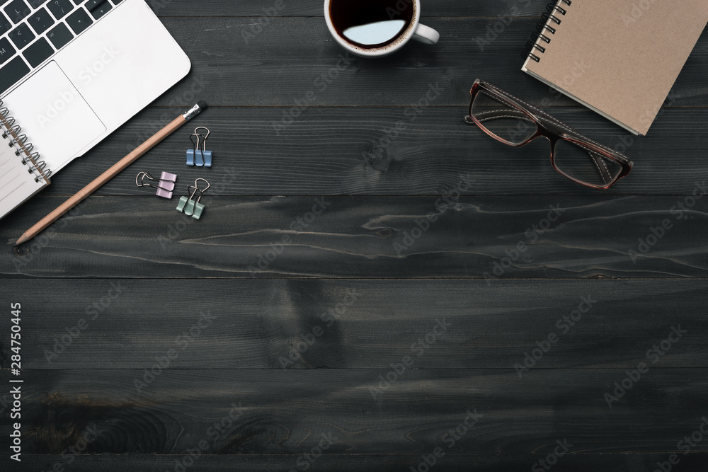 Modern dark wood office desk table with laptop, smartphone and other ...