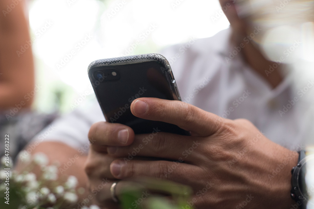 Mano de hombre sosteniendo celular con camisa blanc ay anillo persona ...