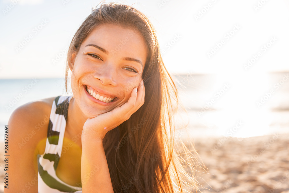 Woman smile happy on beach with healthy glowing skin on sunset sun ...