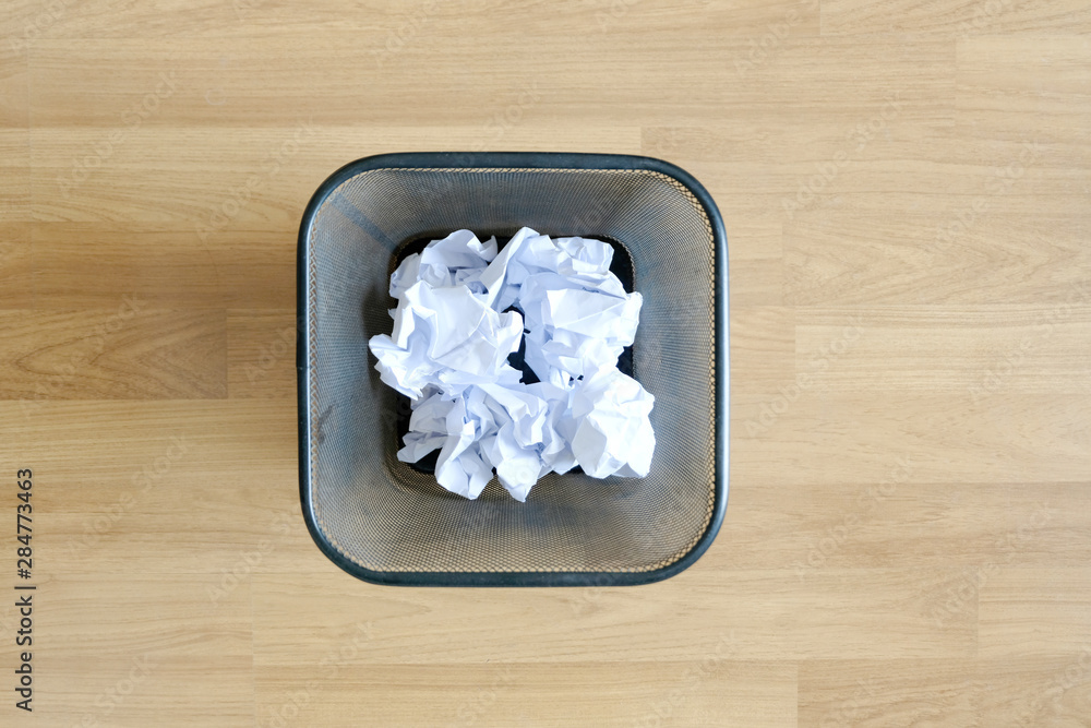 Throwing many crumpled paper ball into black garbage at the office. Its ...