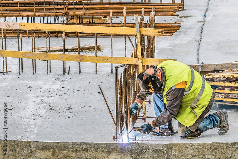 Welder in welding steel bars. Process by Shielded Metal Arc Welding ...