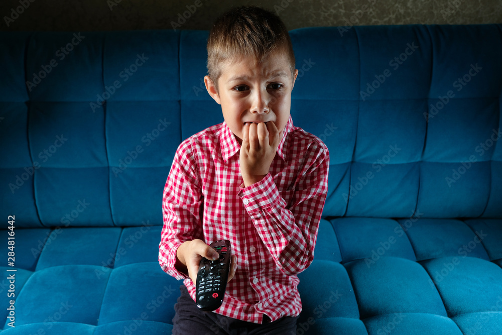Small boy on the couch watching TV at night in the living room. Child ...