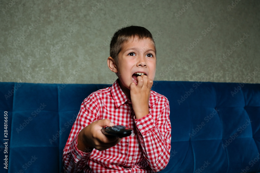 Small boy on the couch watching TV at night in the living room. Child ...