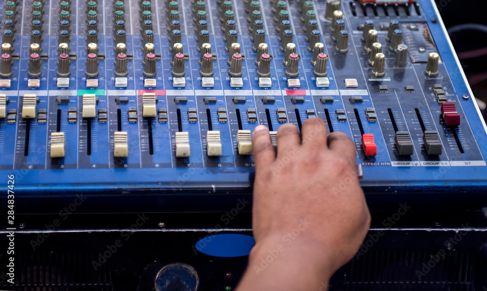 Sound manager is working on an audio mixer, preparing a new mix of ...