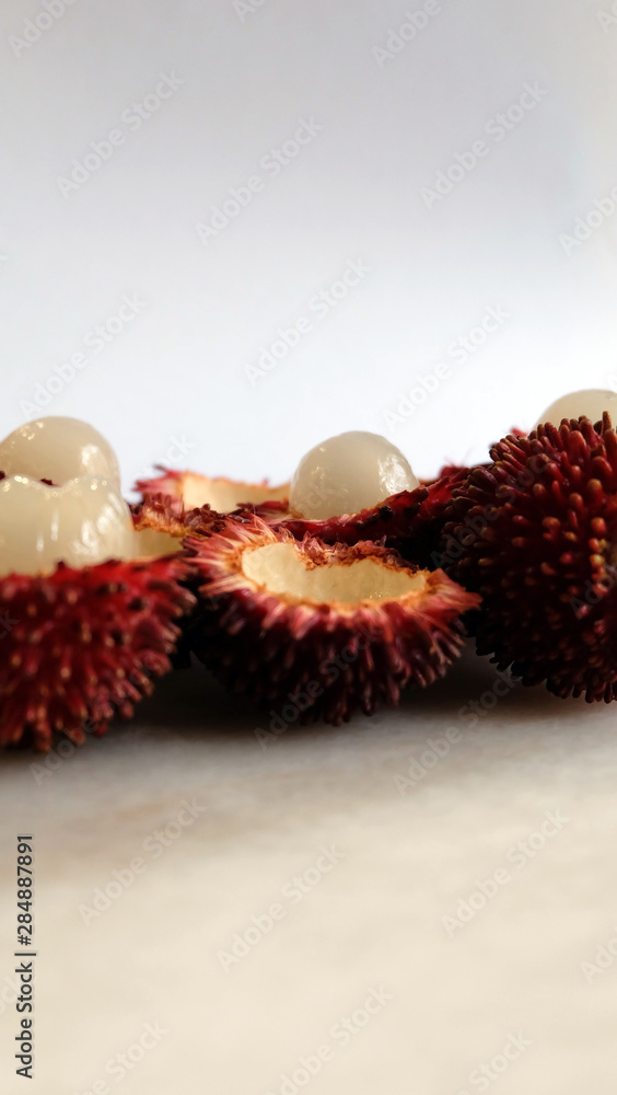 Peeled pulasan fruits in vertical photo. Scientific name Nephelium ...