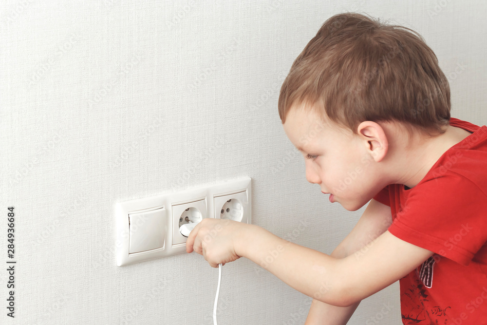 Toddler playing with electric plug at home. Dangerous situation for ...