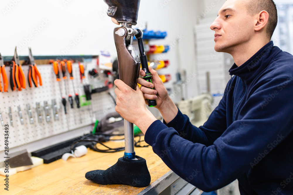 Disabled man working in amputee shop for production prosthetic ...