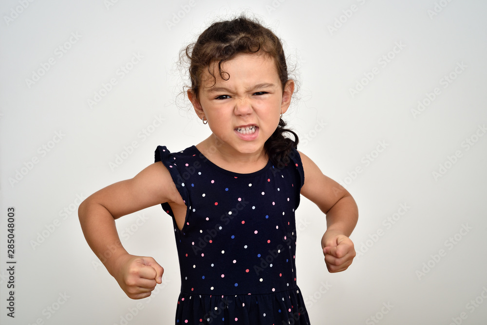 Angry and aggressive young girl with clenched teeth and fists looking ...