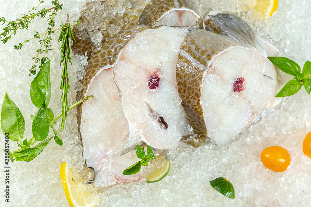 fresh sea ocean white fish sliced in pieces, lying on ice, headless ...