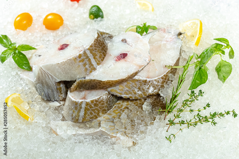 fresh sea ocean white fish sliced in pieces, lying on ice, headless ...