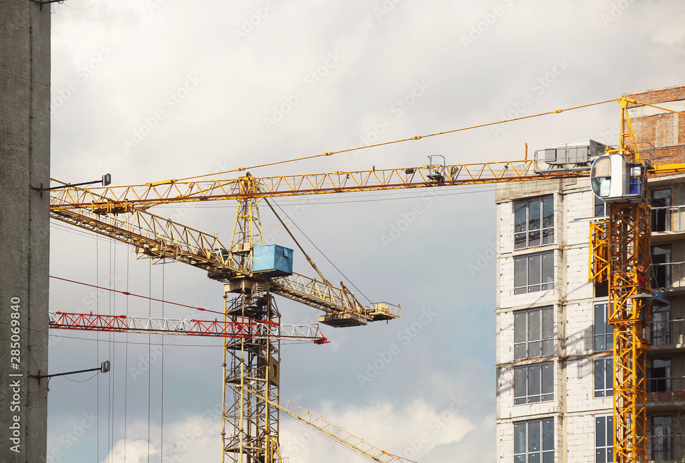 Tower cranes work during the construction of a multi-story building ...