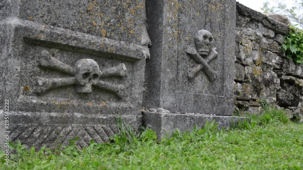 Skull and crossbones gravestone on old cemetery. A tomb with Symbol of ...