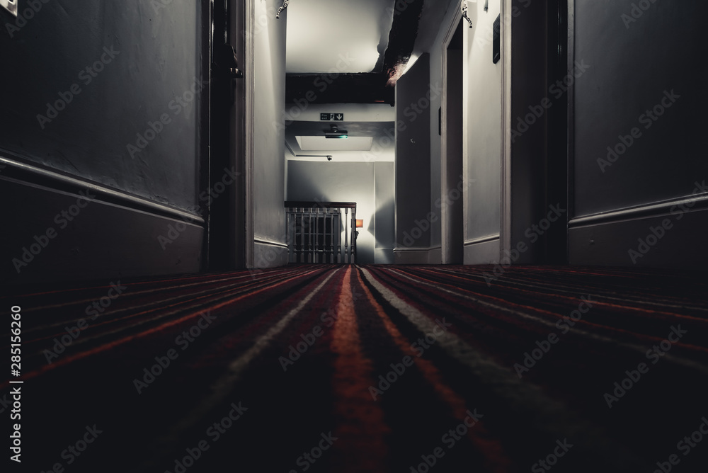 Fotka „Exit fire sign hanging on ceiling on dark mysterious corridor in ...