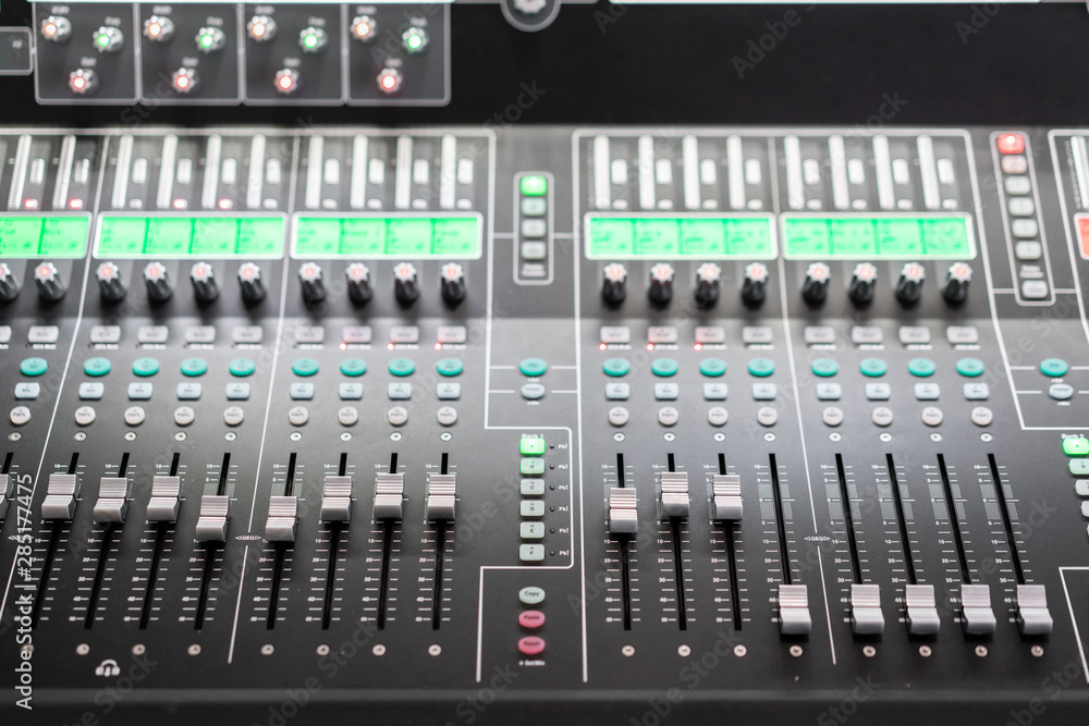 od adjusters and red buttons of a mixing console. It is used for audio ...