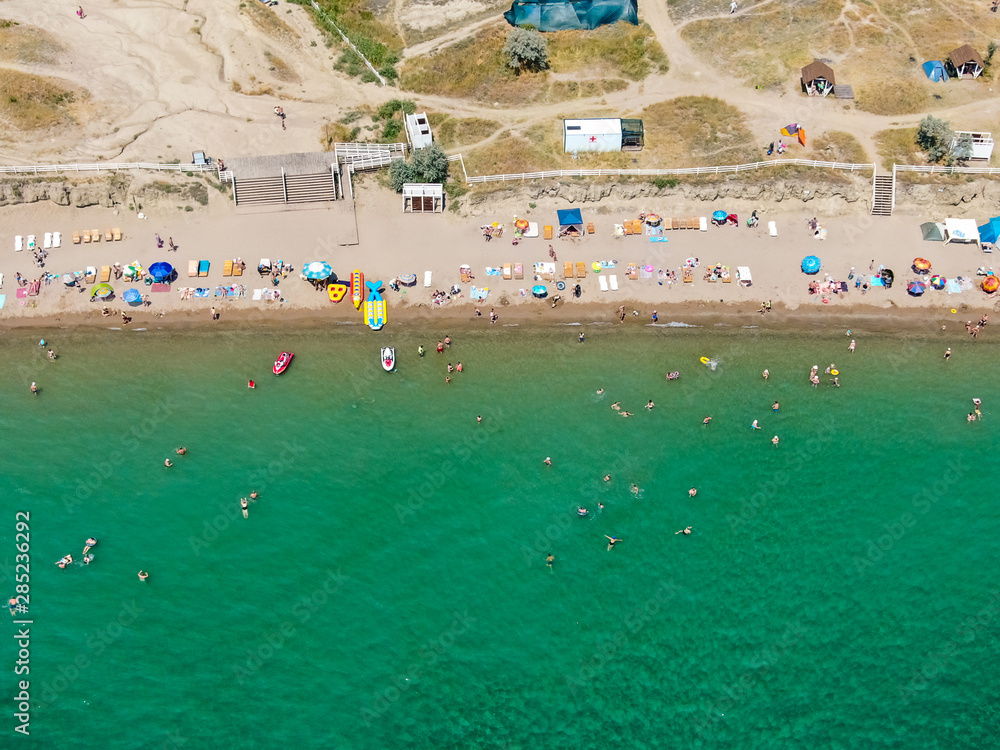 Bird's-eye view. Sea beach people swimming sunbathing relaxing. Human ...