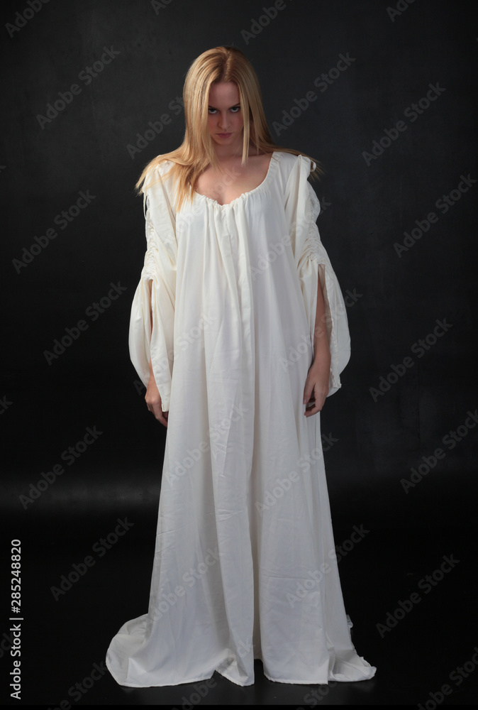 full length portrait of blonde girl wearing long white flowing robe ...
