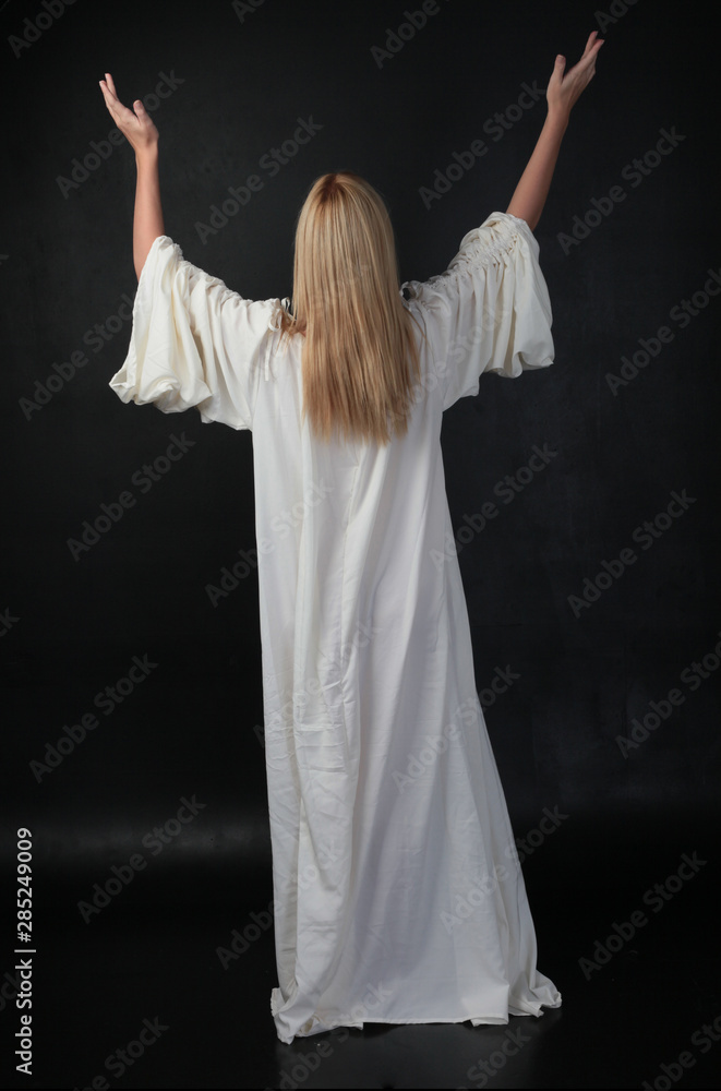 full length portrait of blonde girl wearing long white flowing robe ...