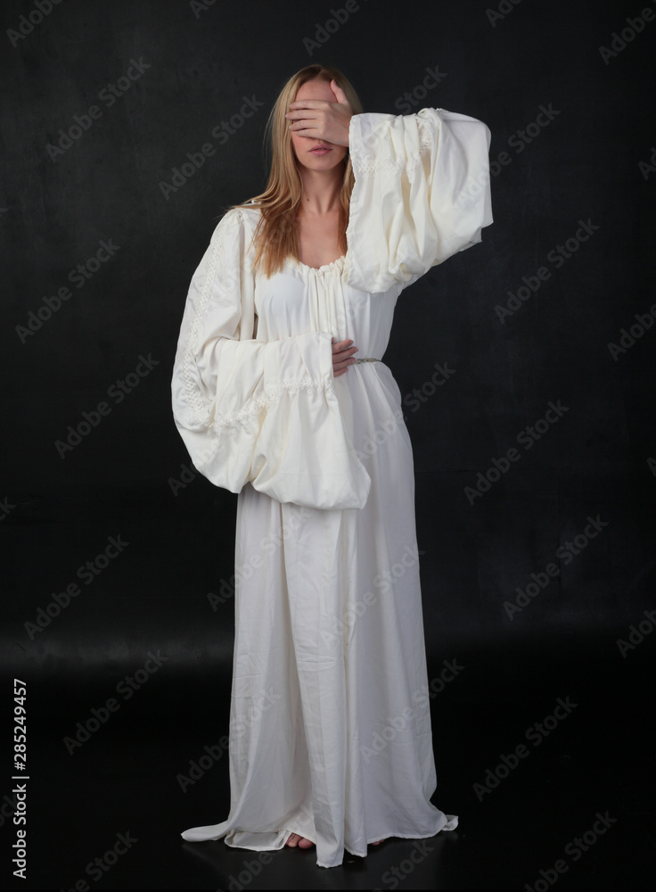 full length portrait of blonde girl wearing long white flowing robe ...