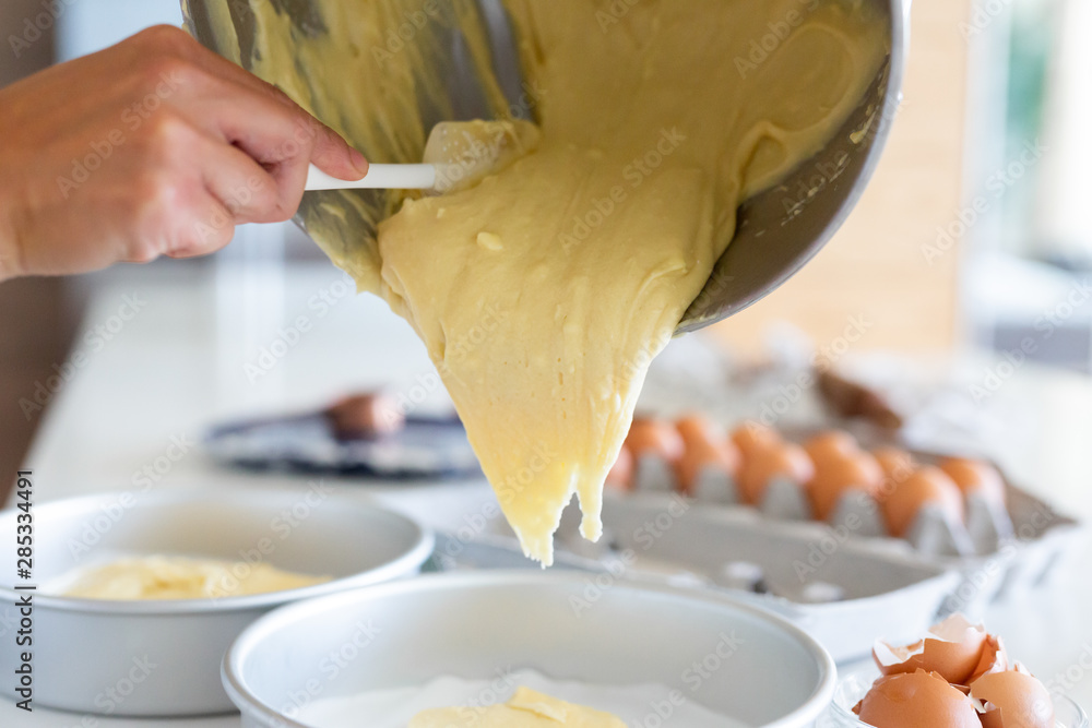 Pouring Cake Batter Out of Mixing Bowl Stock Photo | Adobe Stock