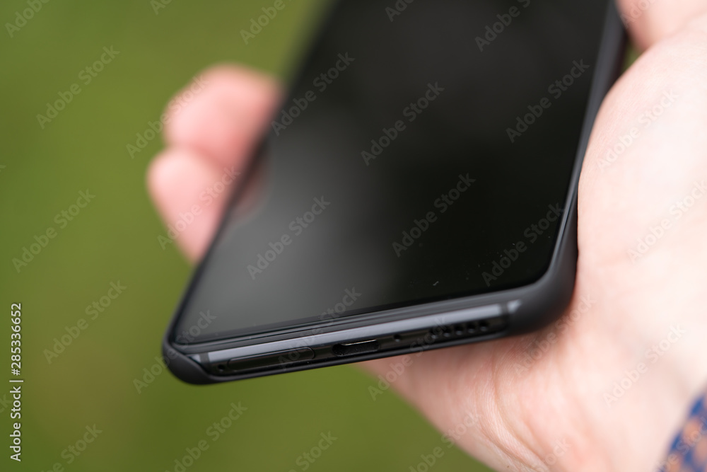 smartphone in hand. bottom with connectors in focus. macro photo detail ...