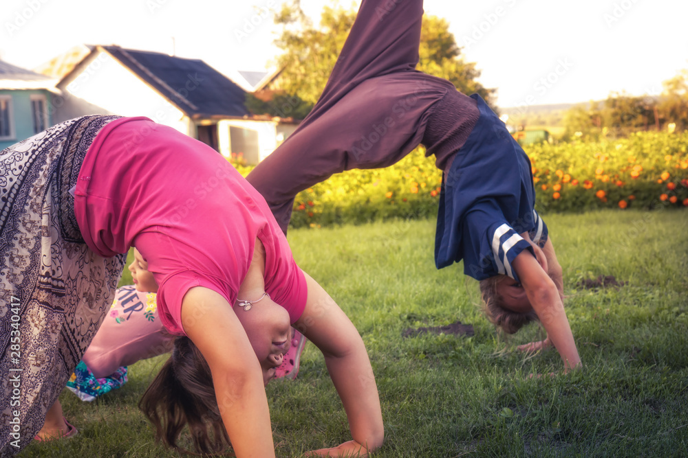 Happy children making exercise yoga outdoors on grass concept healthy ...