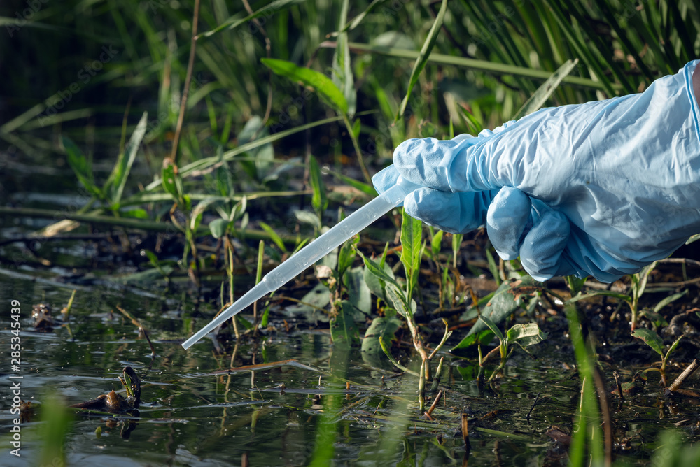 Water pollution concept. Woman scientist takes a water sample from ...