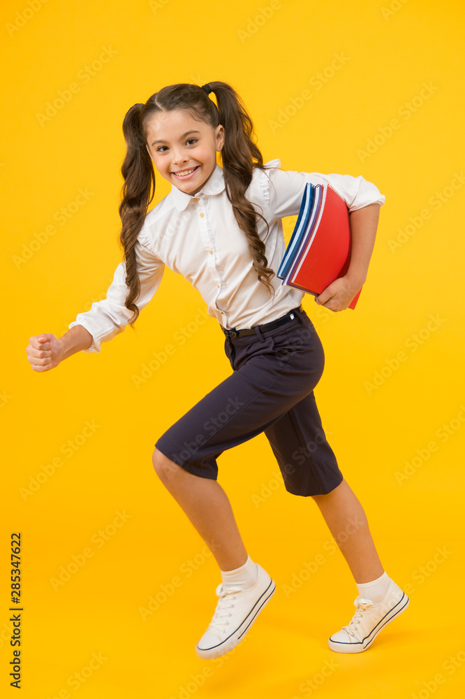 Hurry to the library. Cute small child running to library on yellow ...