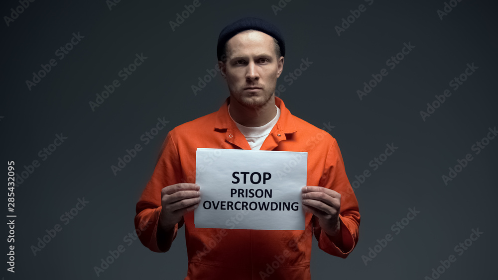Prisoner holding Stop prison overcrowding sign in cell, life conditions ...