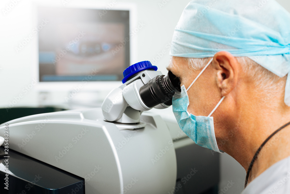 Professional serious doctor using the microscope for work Stock Photo ...