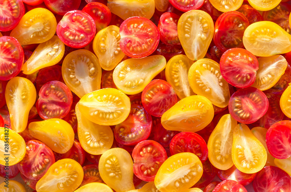 Fresh halves of Mexican cherry tomatoes. Sliced yellow and red cherry ...